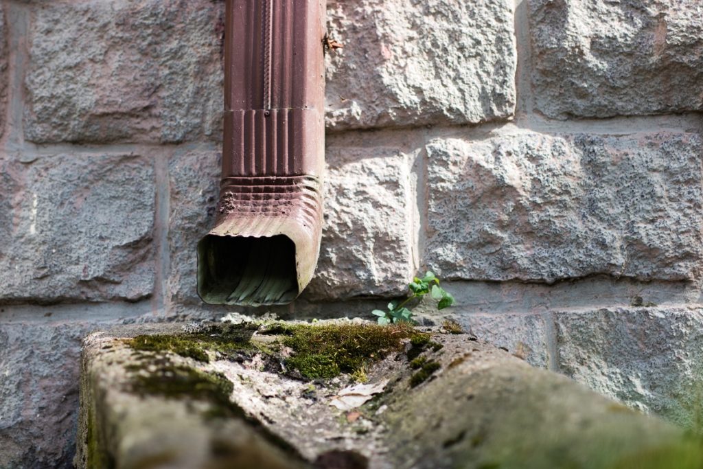 A gutter mounted on the wall of the building - Christiansonco